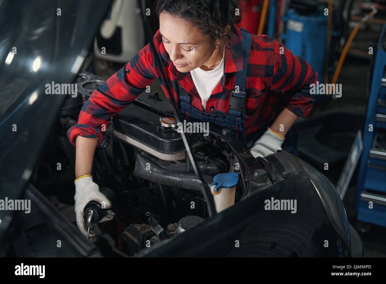 Female auto mechanic repairing vehicle in car garage Stock Photo - Alamy