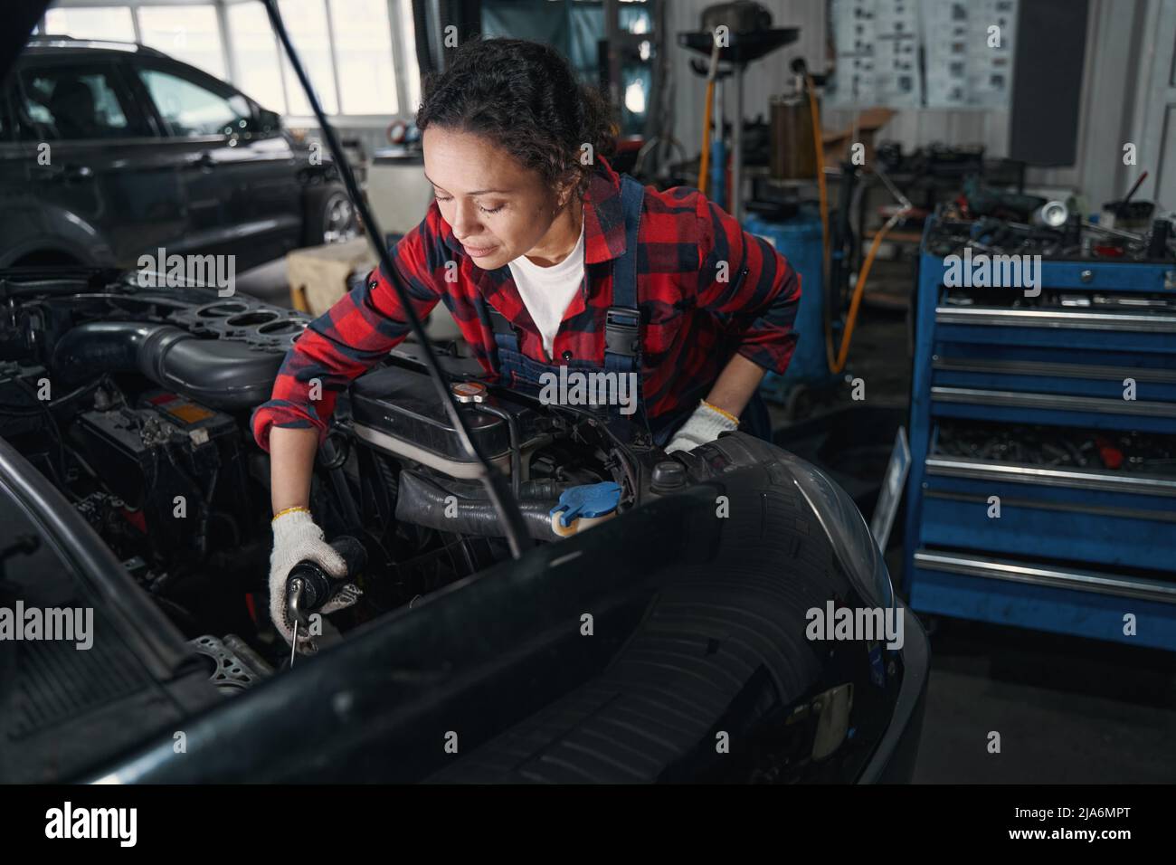 Woman auto mechanic repairing vehicle in car garage Stock Photo - Alamy