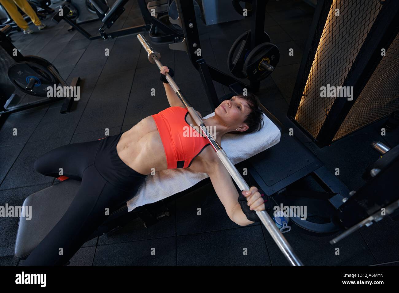 Professional sportswoman bench-pressing during workout at gym Stock ...