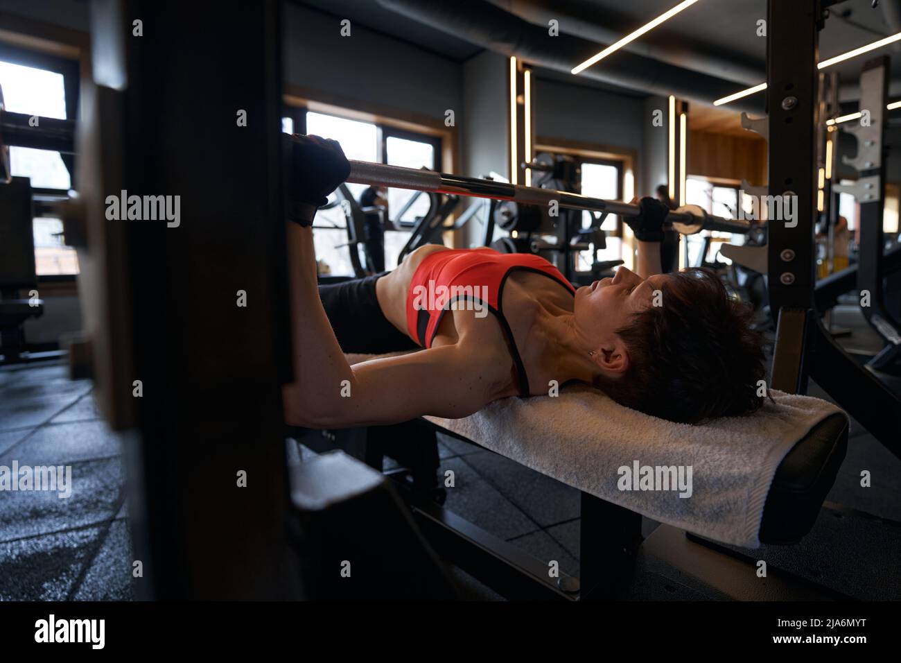 Strong muscular female bodybuilder bench-pressing at gym Stock Photo ...