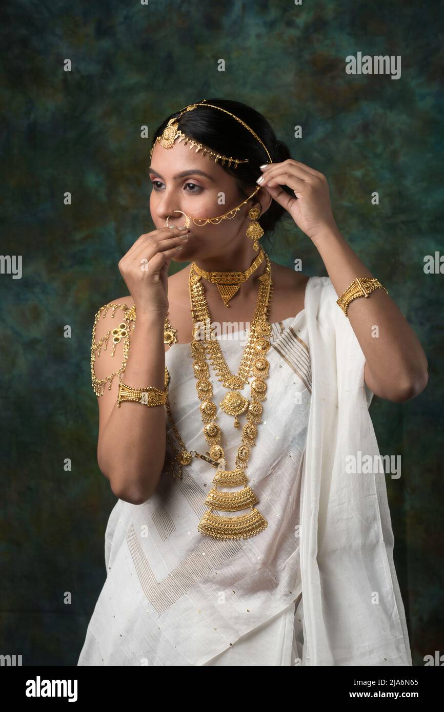 indian woman in a traditional white saree and gold jewellry to ...