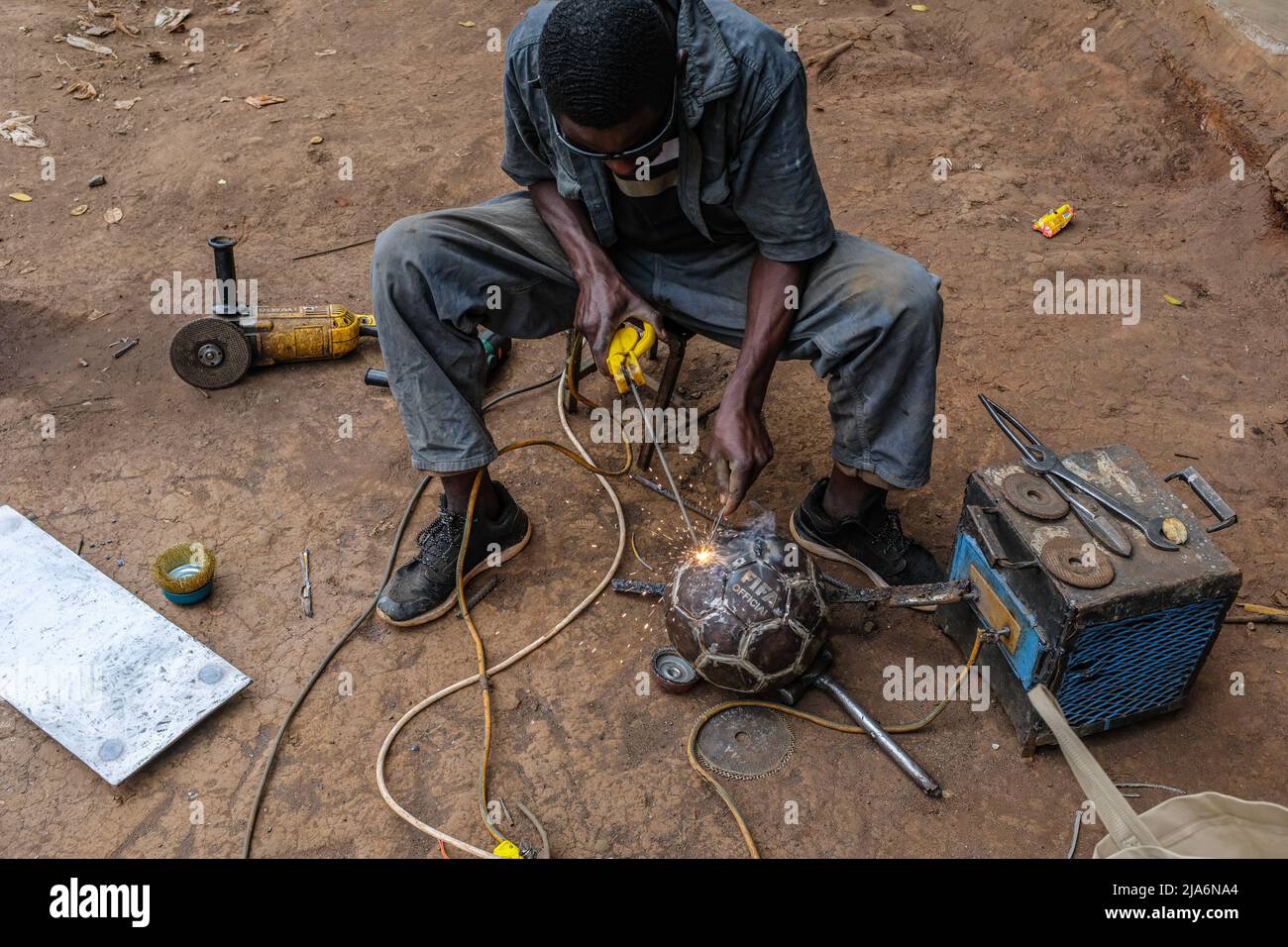 A metalsmith designs a special metallic football art to be used as a ...