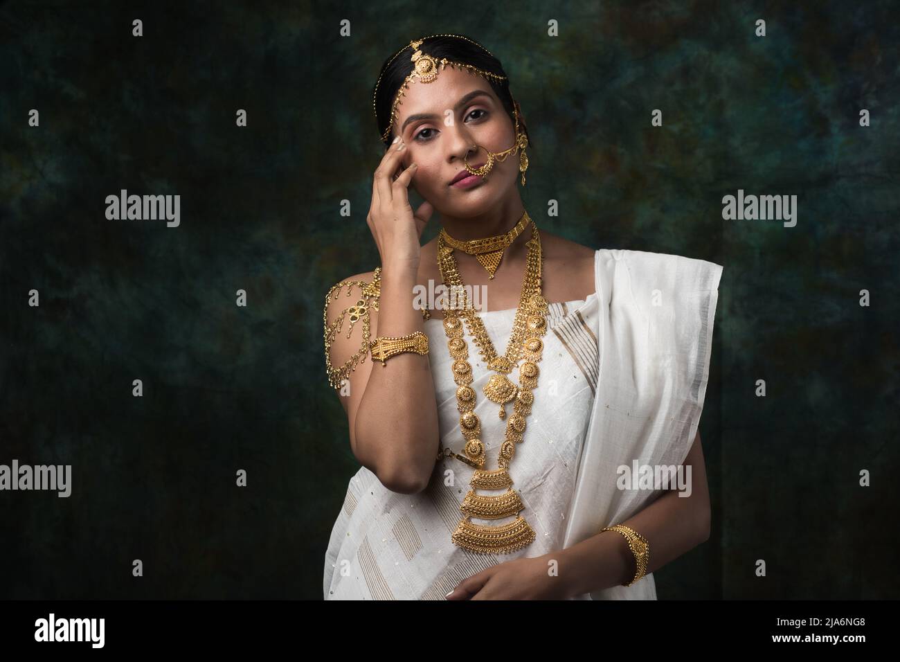 indian woman in a traditional white saree and gold jewellry to ...