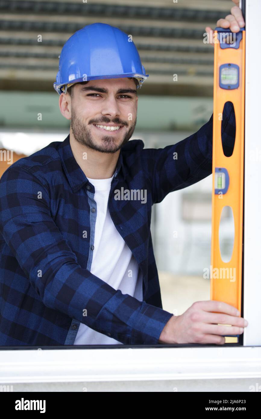 workman is verifying window using a spirit level Stock Photo - Alamy