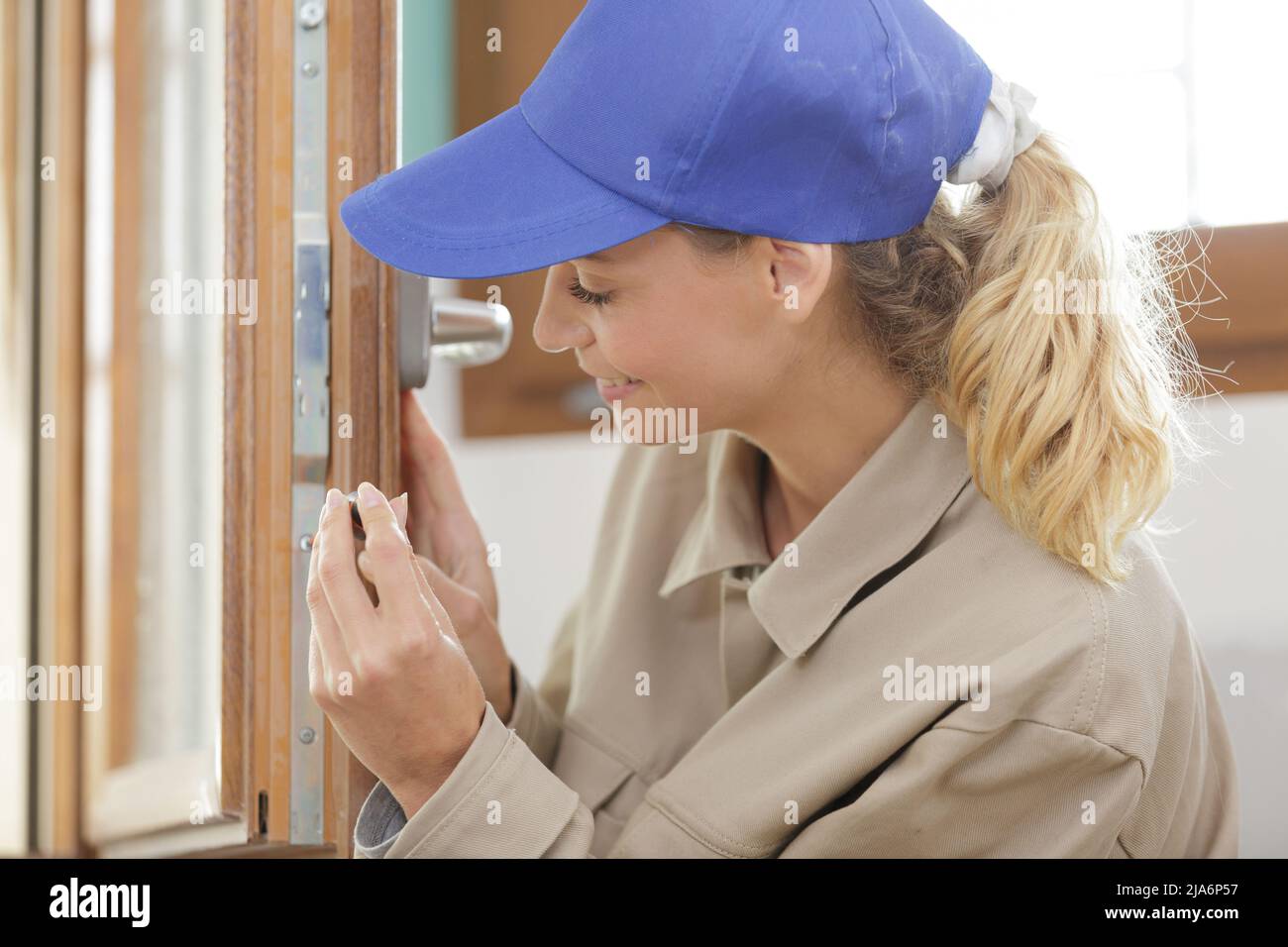 female builder fixing the window Stock Photo - Alamy