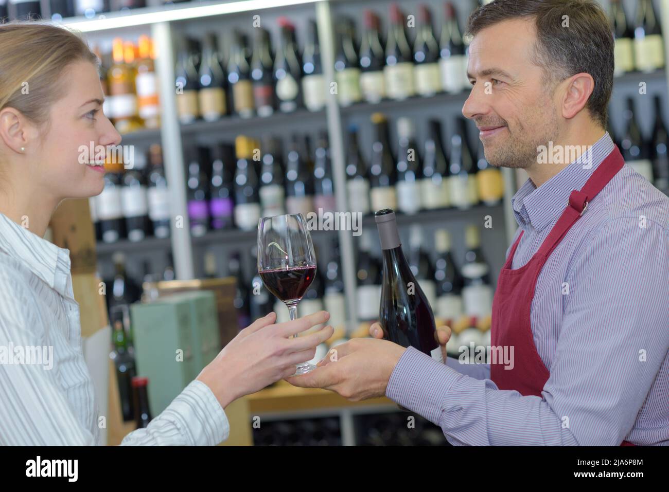 young spanish glad female customer tasting wine before purchasing Stock ...