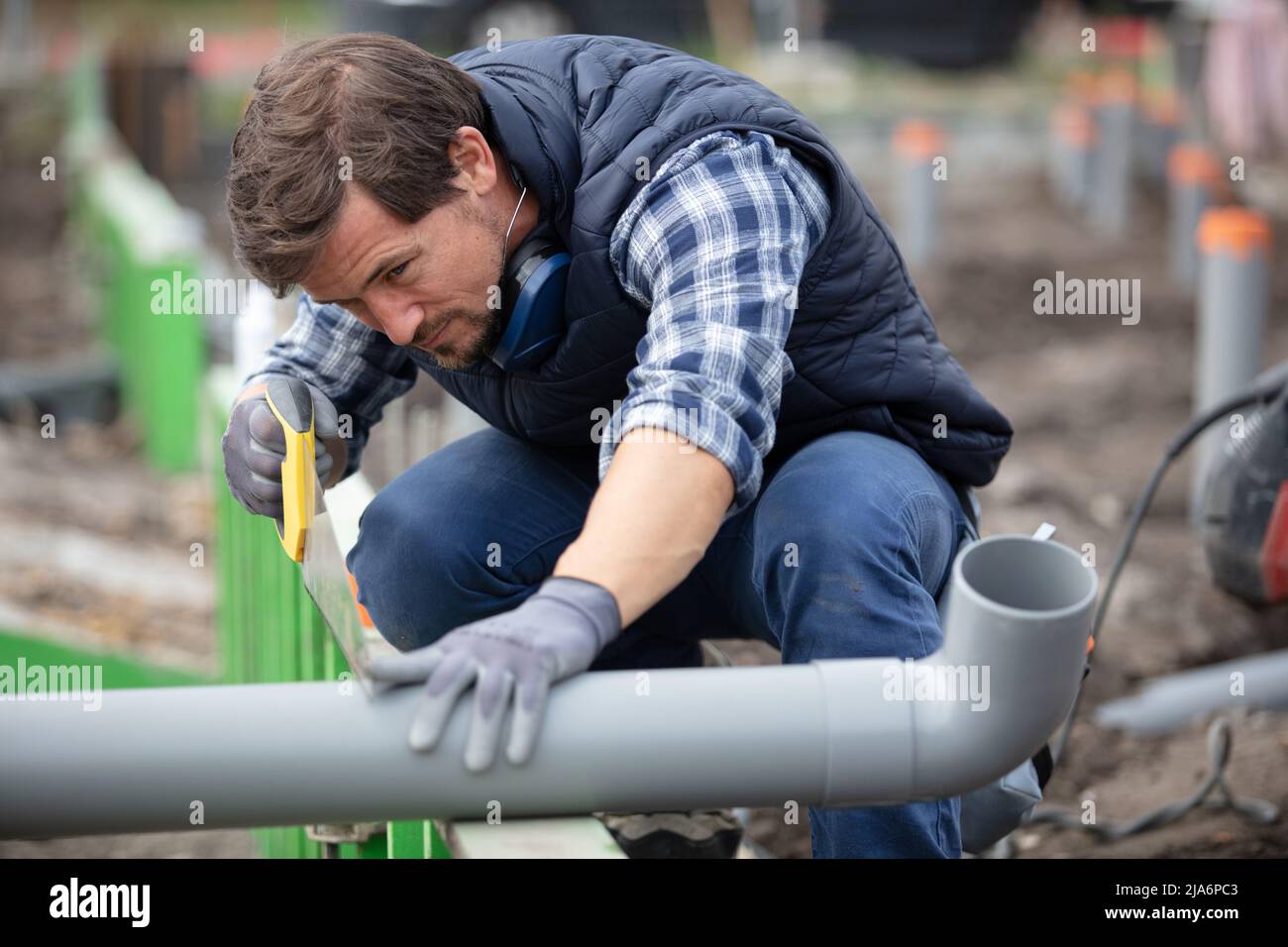 workman saws a pvc waste pipe Stock Photo - Alamy