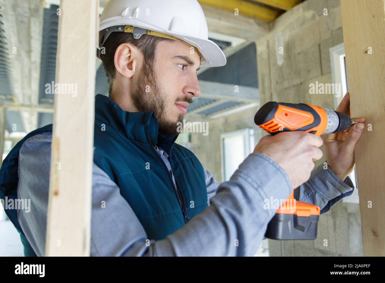 a builder drilling holes on the wall Stock Photo - Alamy