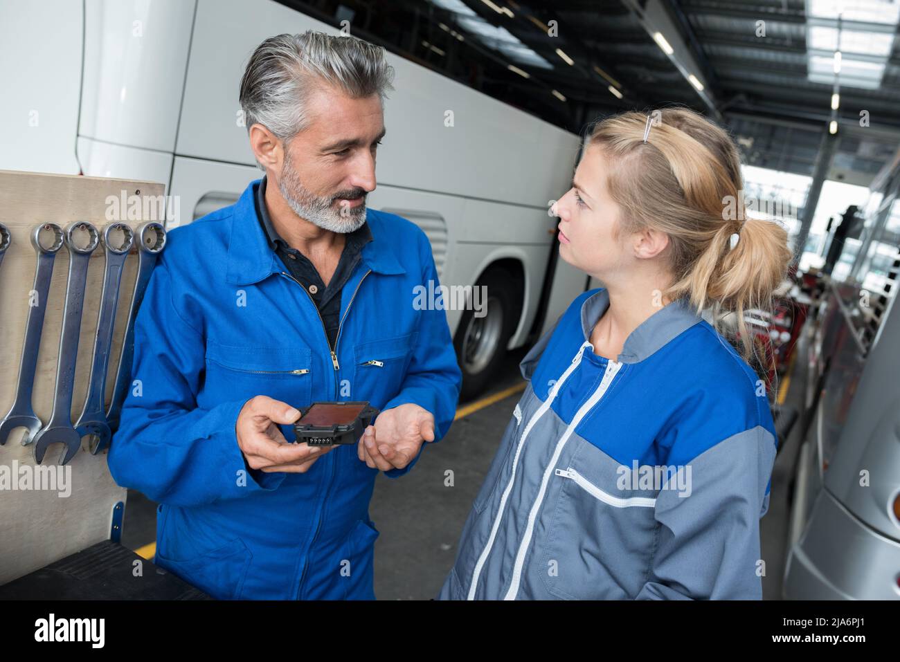 a bus mechanics in conversation Stock Photo - Alamy