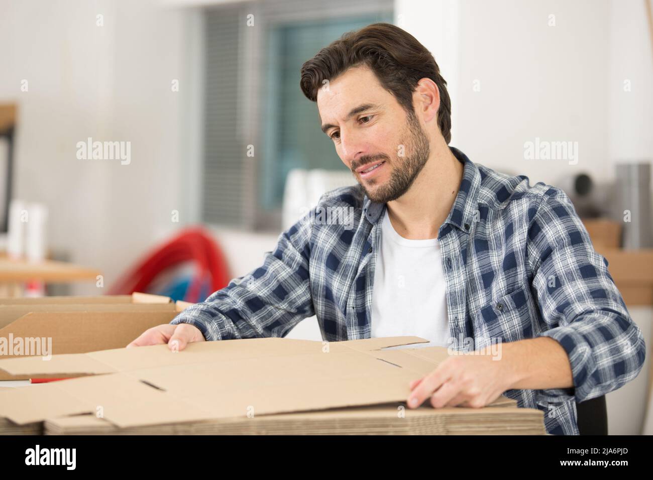 male worker assembling a cardboard box from a template Stock Photo - Alamy