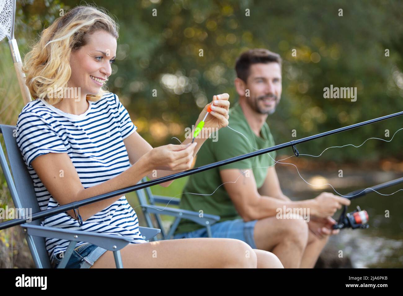 young girl by the river with a fishing rod Stock Photo - Alamy