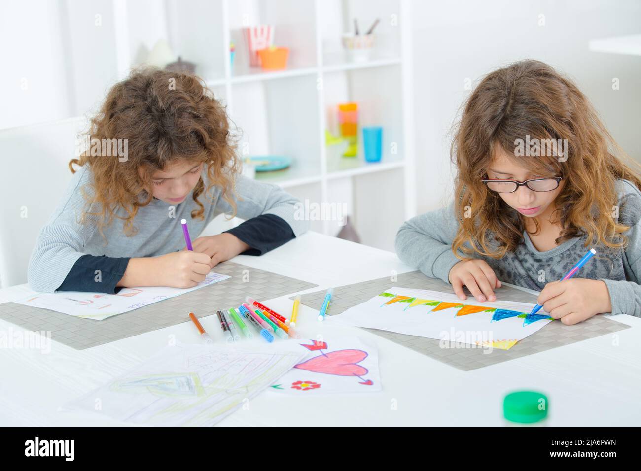 two girls are colouring in Stock Photo - Alamy