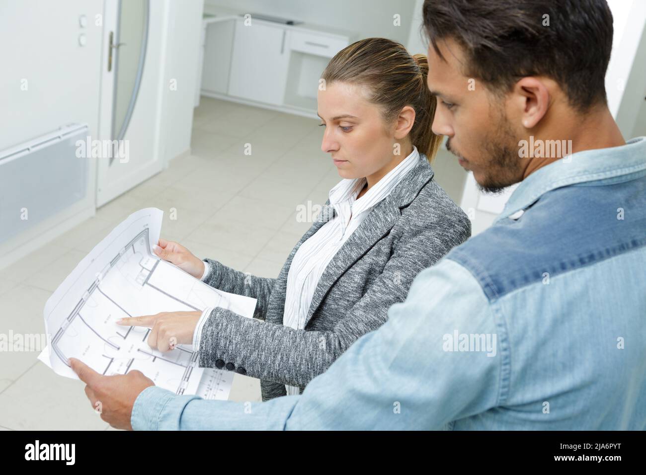 man and woman hold a project plan in the building Stock Photo - Alamy