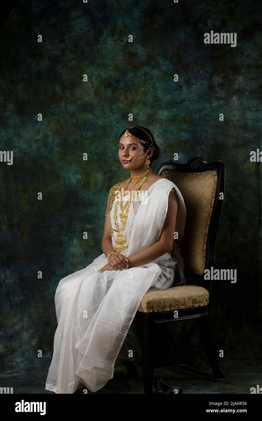 indian woman in a traditional white saree and gold jewellry to ...
