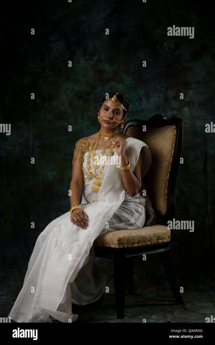 indian woman in a traditional white saree and gold jewellry to ...