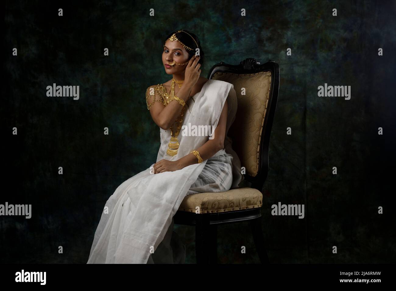indian woman in a traditional white saree and gold jewellry to ...