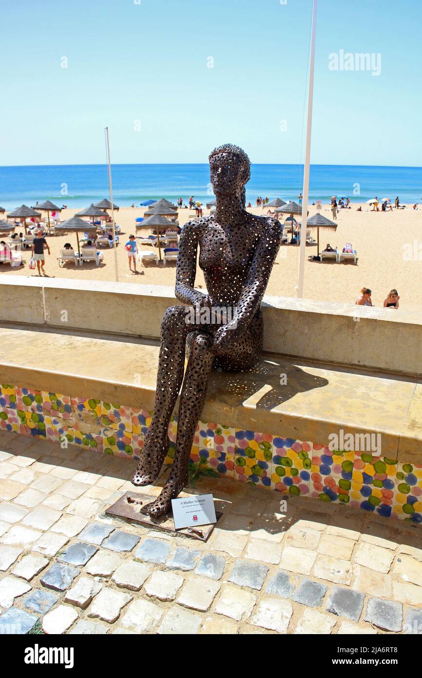 Bronze statue sitting on promenade, Albufeira beach, Portugal Stock ...
