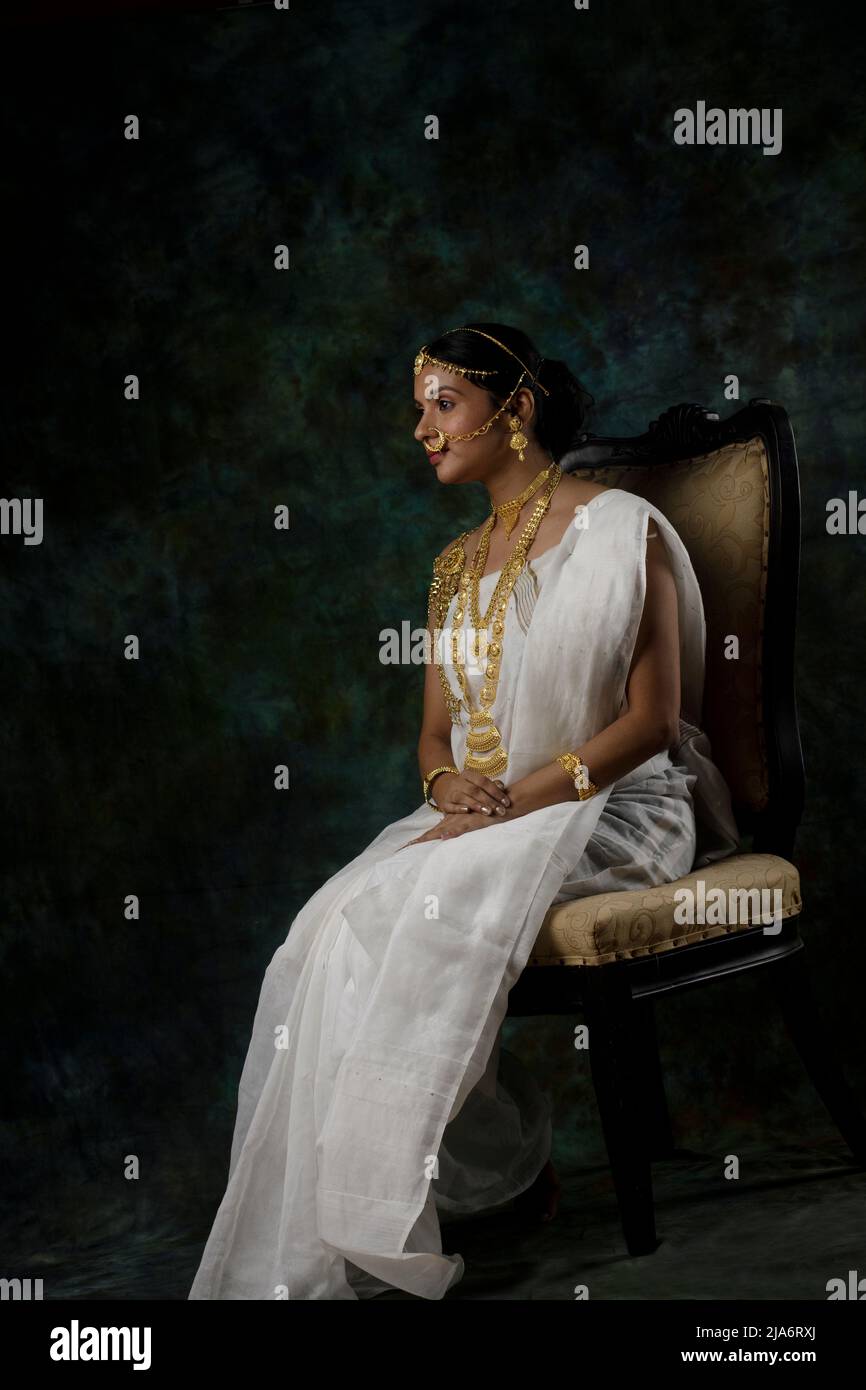 indian woman in a traditional white saree and gold jewellry to ...