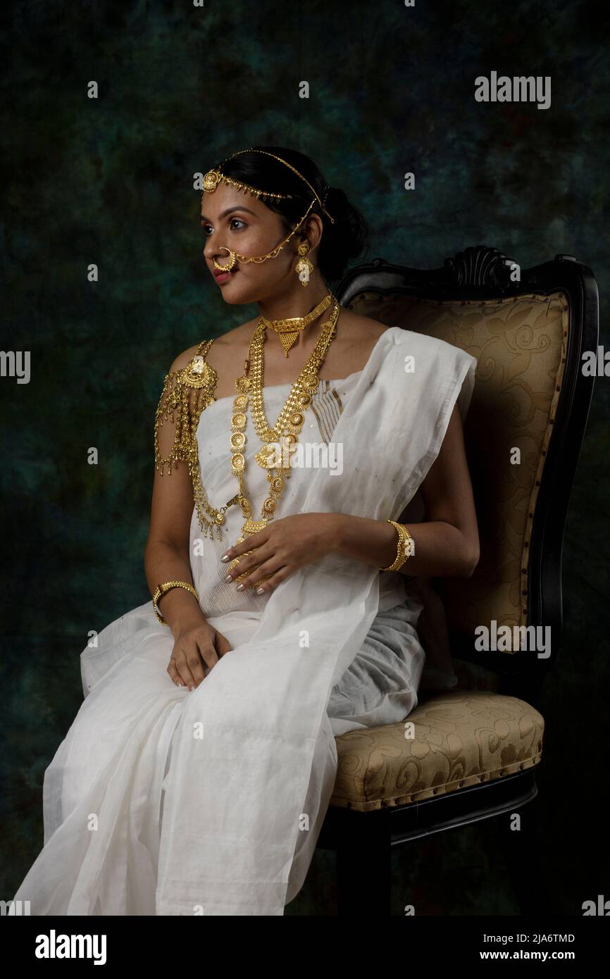 indian woman in a traditional white saree and gold jewellry to ...