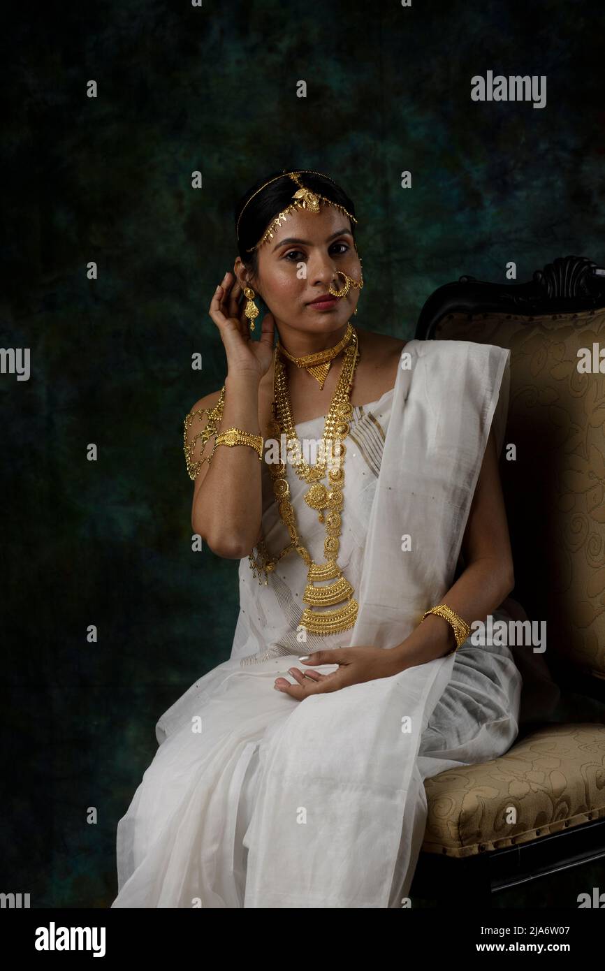 indian woman in a traditional white saree and gold jewellry to ...