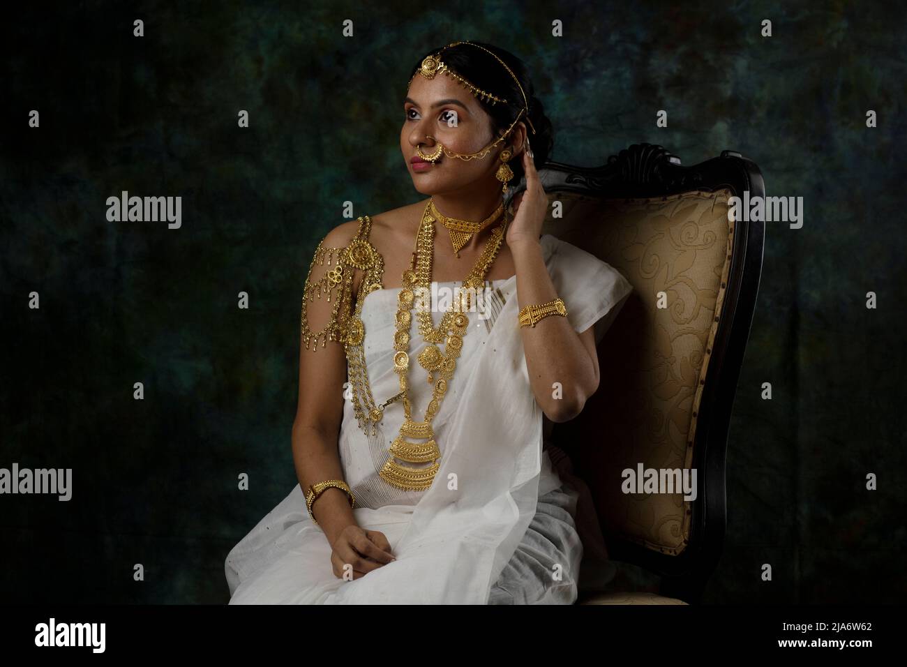 indian woman in a traditional white saree and gold jewellry to ...