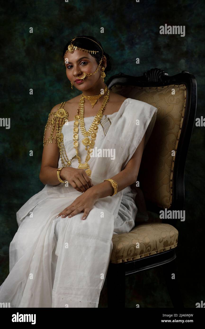 indian woman in a traditional white saree and gold jewellry to ...