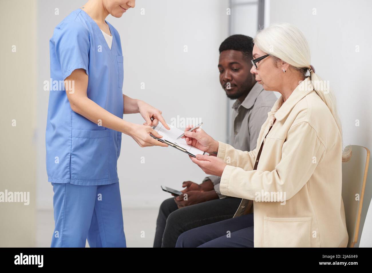 Side view shot of stylish senior woman sitting in queue in hospital ...