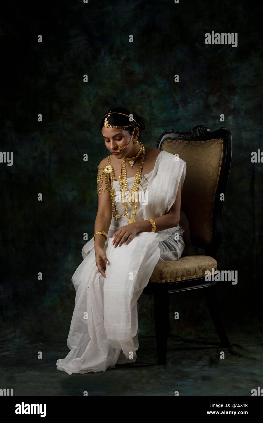indian woman in a traditional white saree and gold jewellry to ...