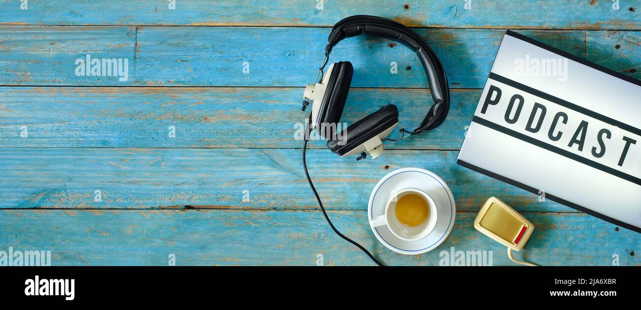 Podcast word on lightbox, headphones, vintage microphpne and cup of ...