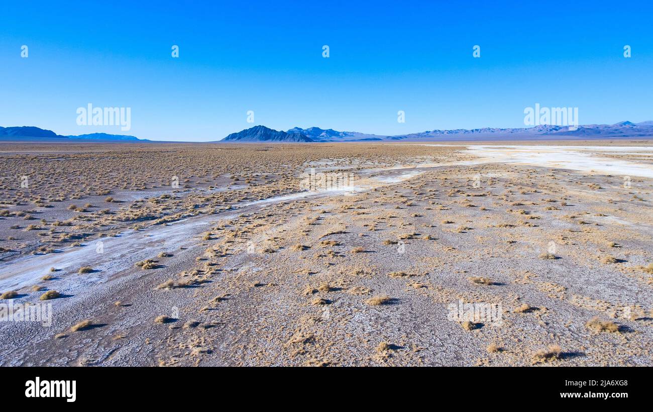 Aerial of open desert landscape with mountains in distance Stock Photo ...