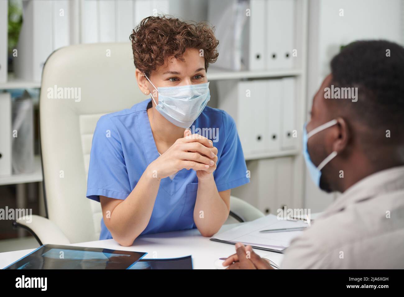 Professional medical worker wearing blue uniform and protective mask ...