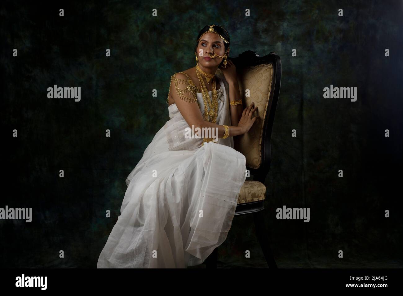 indian woman in a traditional white saree and gold jewellry to ...