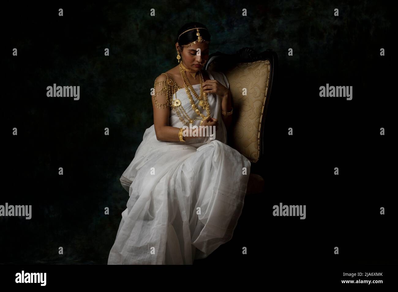 indian woman in a traditional white saree and gold jewellry to ...