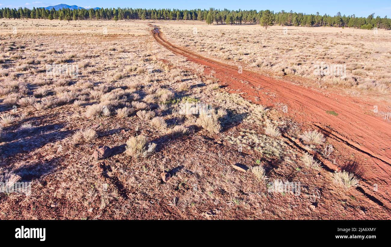 Aerial view of small dirt road going through desert plains Stock Photo ...