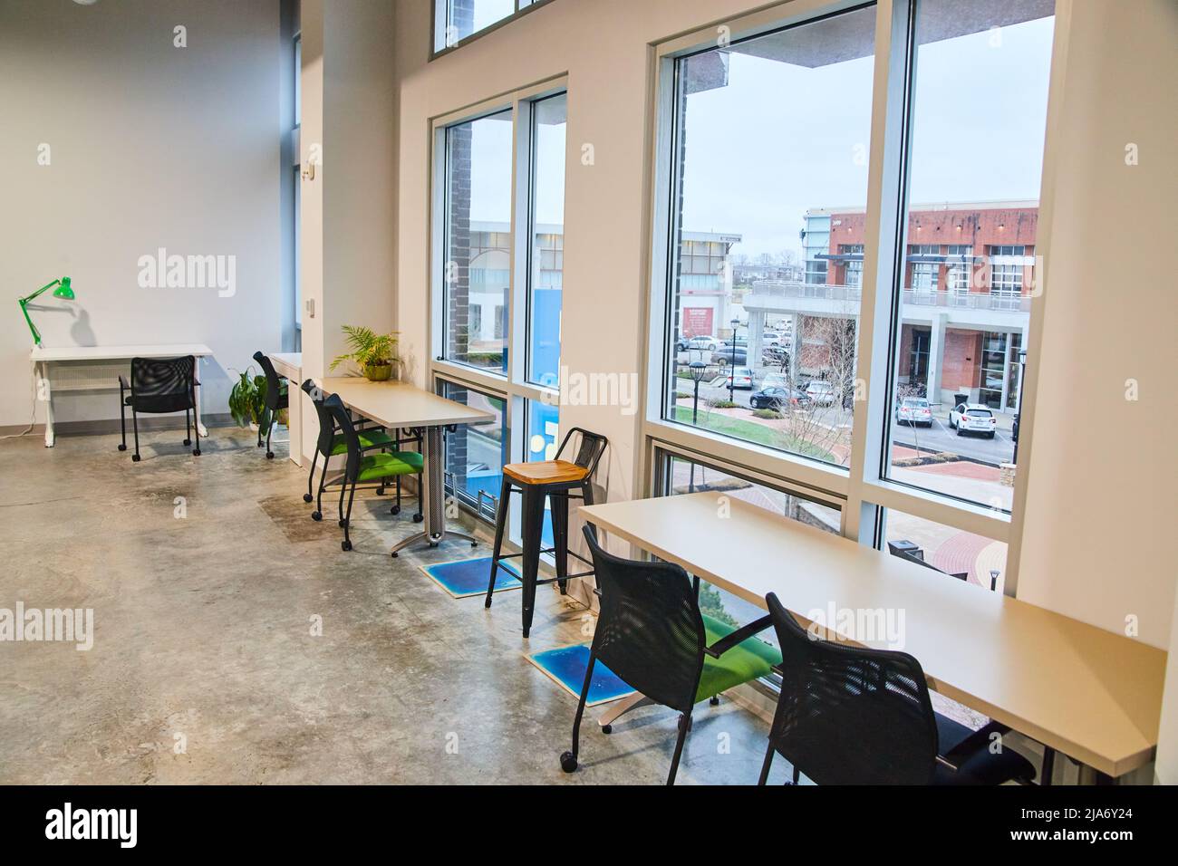 Coworking modern desk space against window Stock Photo - Alamy