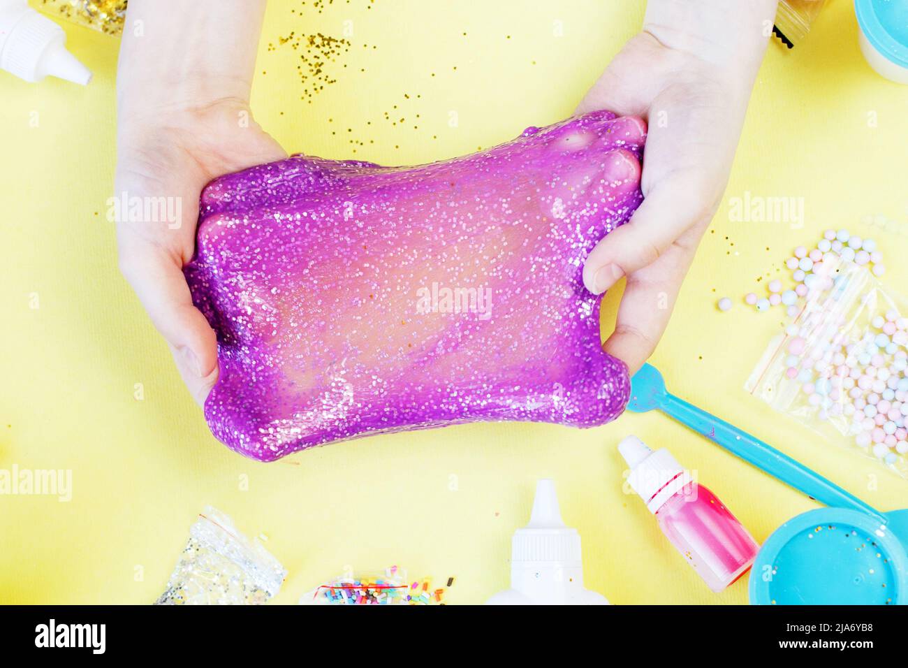 Making slime at home. child holding and stretching colorful slime. DIY ...