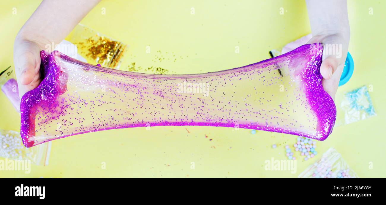 Making slime at home. child holding and stretching colorful slime. DIY ...