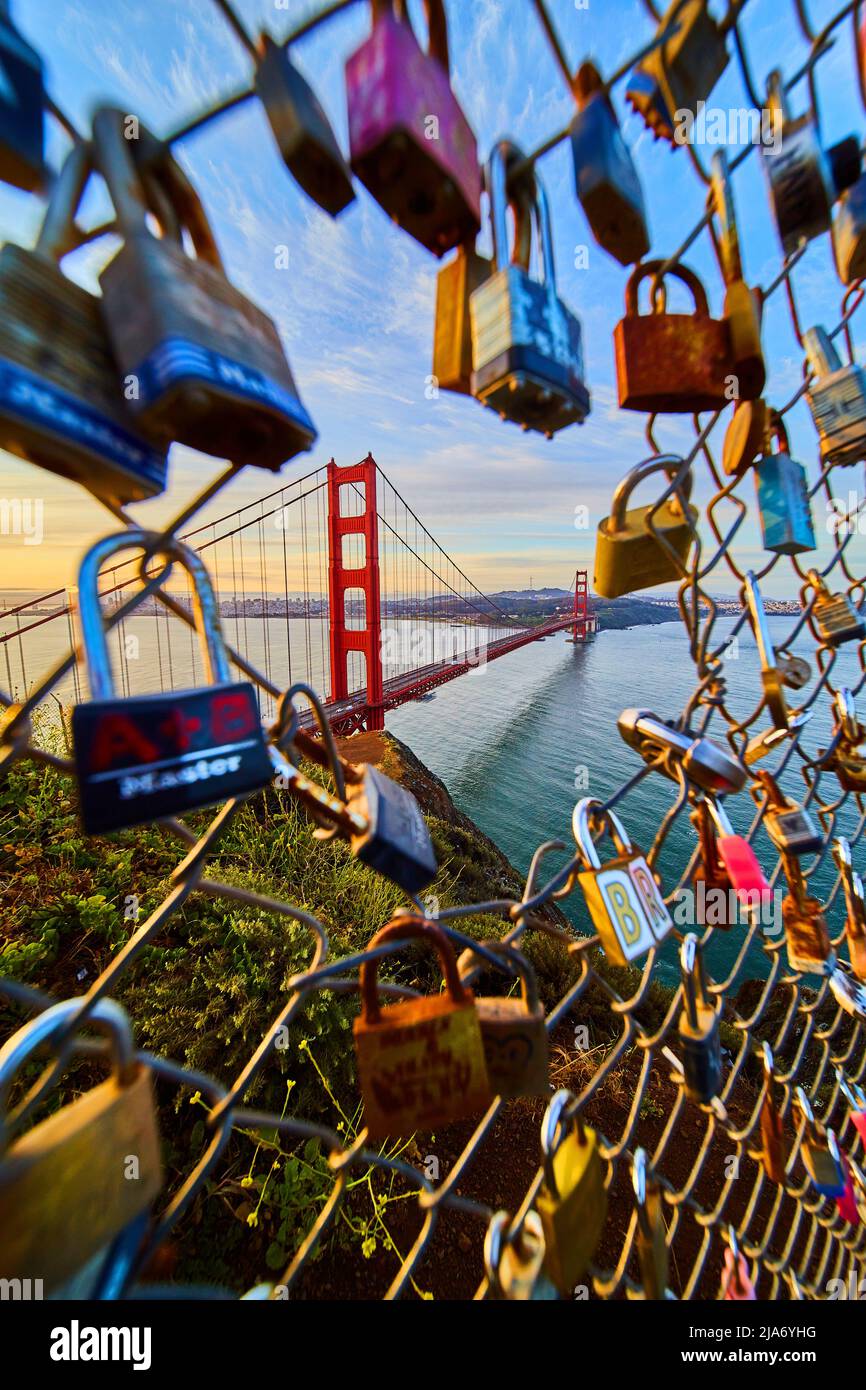 Golden Gate Bridge viewed through chain link fence covered in locks ...