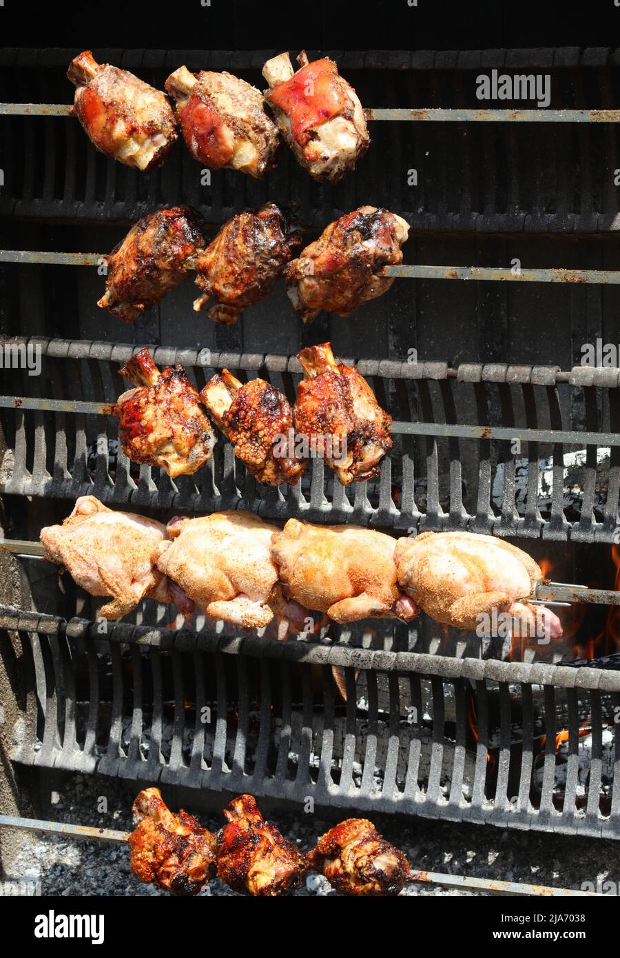 Rotisserie with spit-roasted chickens and pork shank cooked ham meat ...