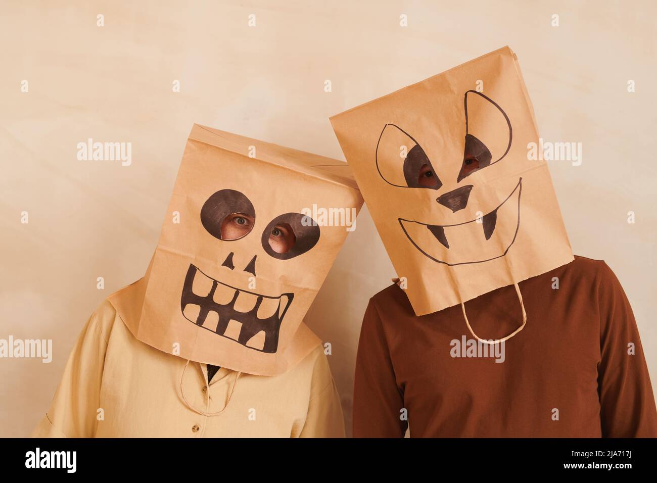 Portrait of friends in funny paper bags standing together against ...