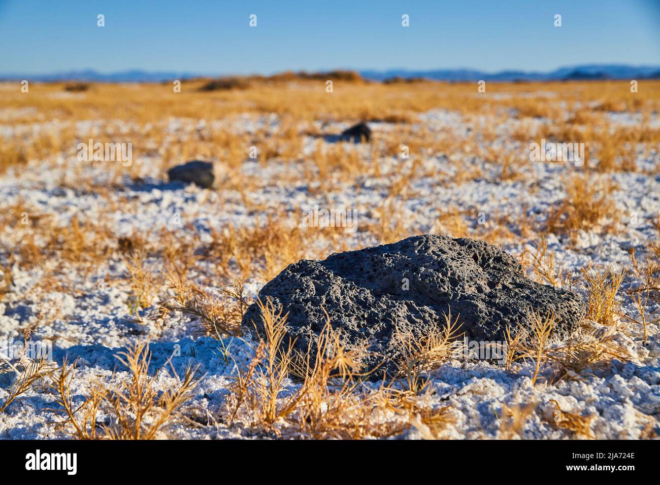 Desert white sand and small black rocks scattered Stock Photo - Alamy