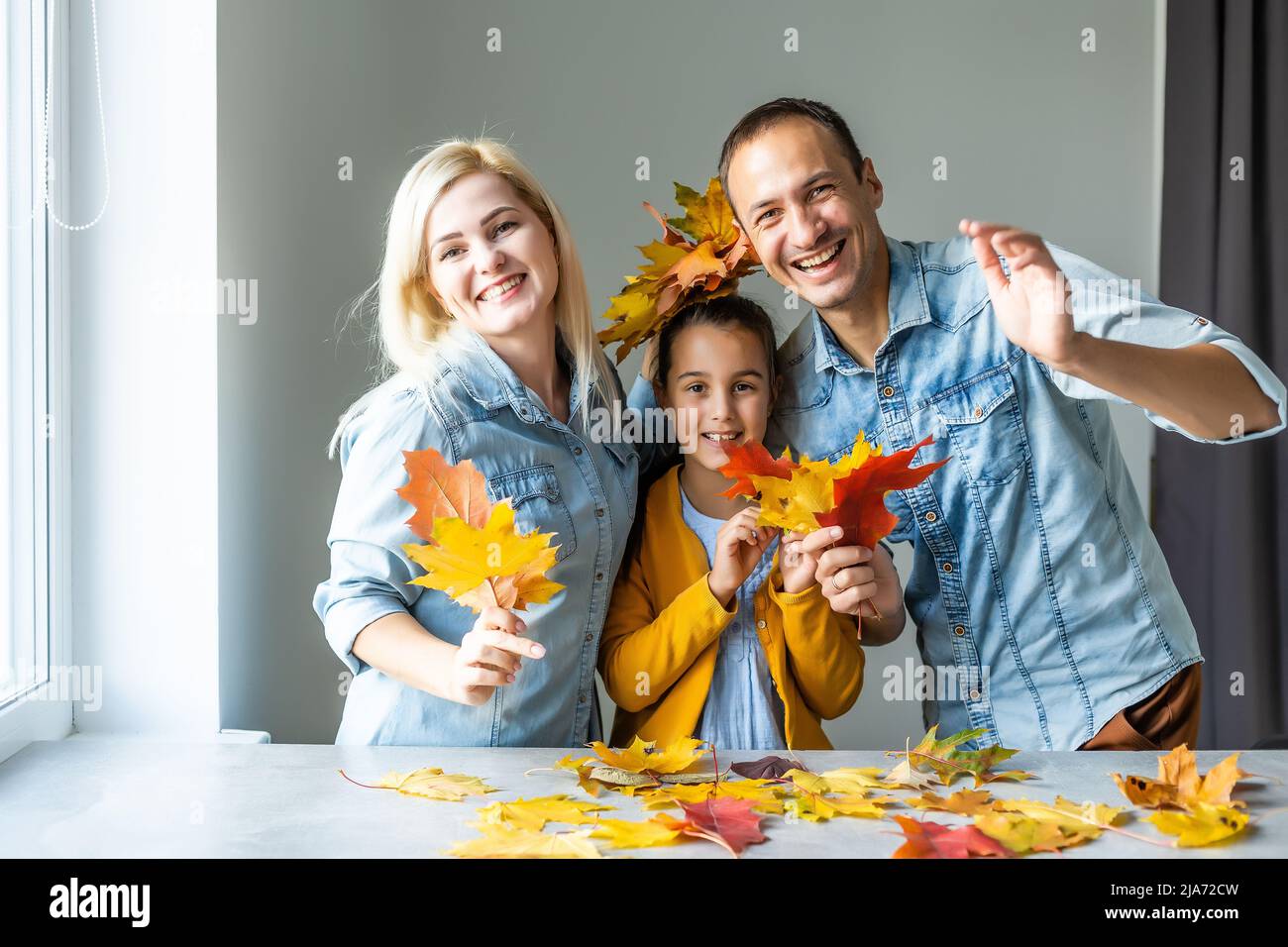 family At Home Doing Craft And Making Picture From Leaves In Kitchen ...
