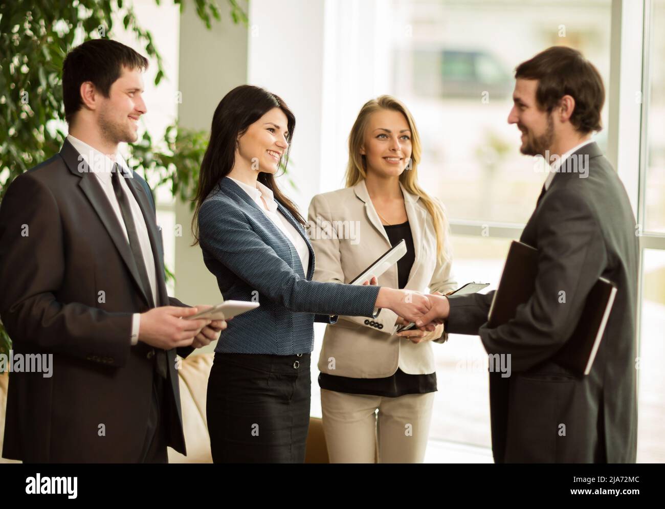 Group of business people congratulating their handshaking colleagues ...