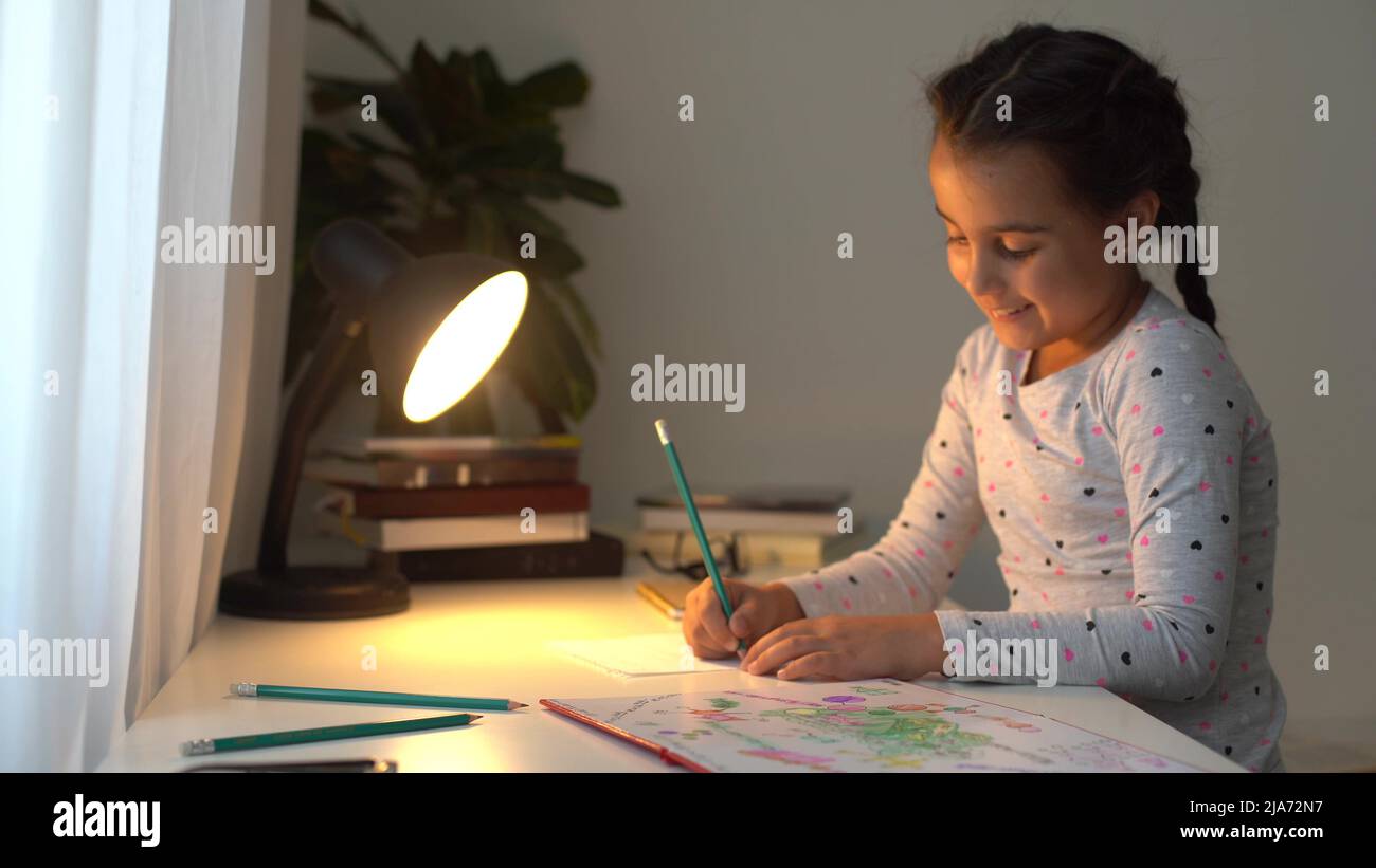 Cute smart primary school child girl learning writing doing math ...