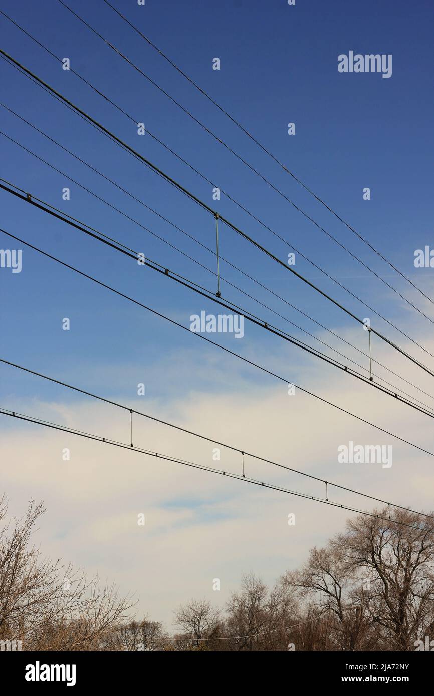 Electrical power lines crossing overhead against the blue sky Stock ...