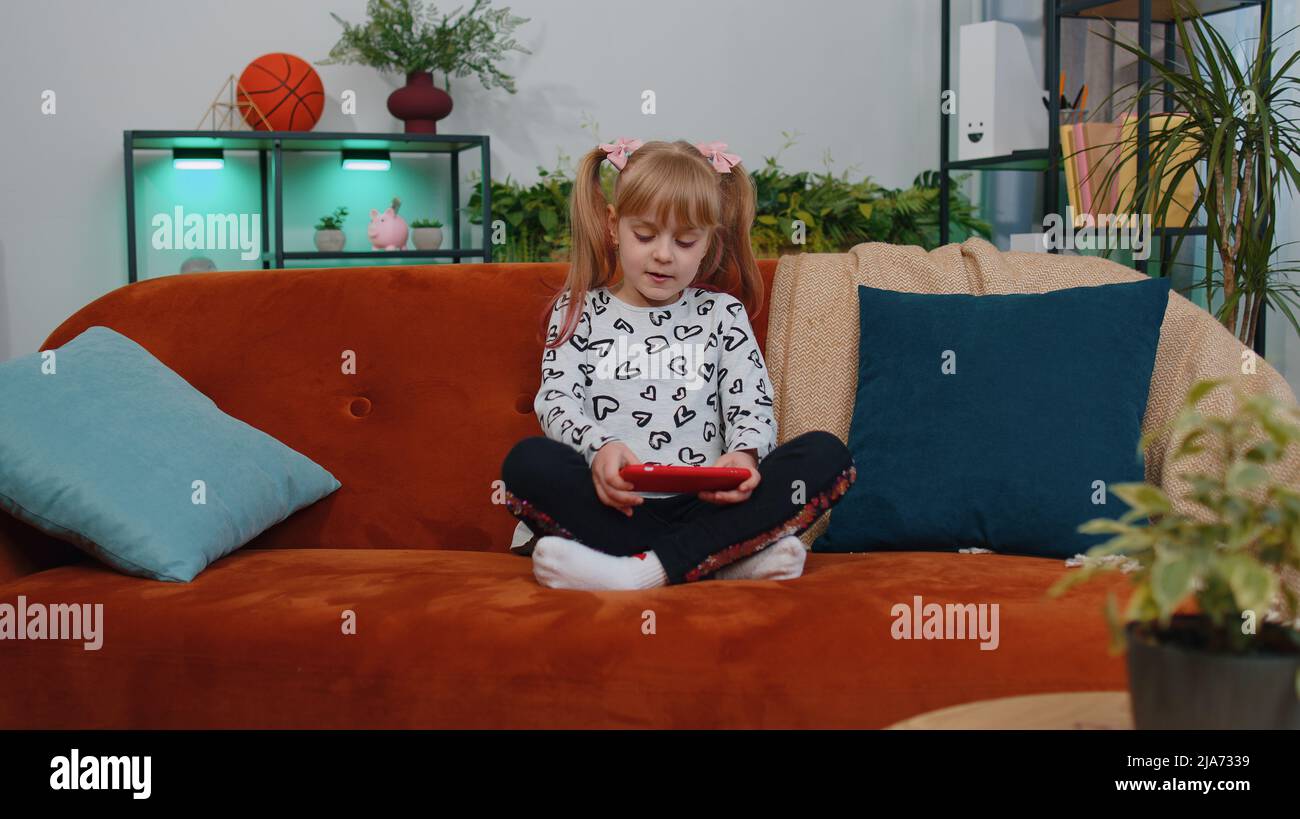 Worried teen child girl kid enthusiastically playing shooter video ...