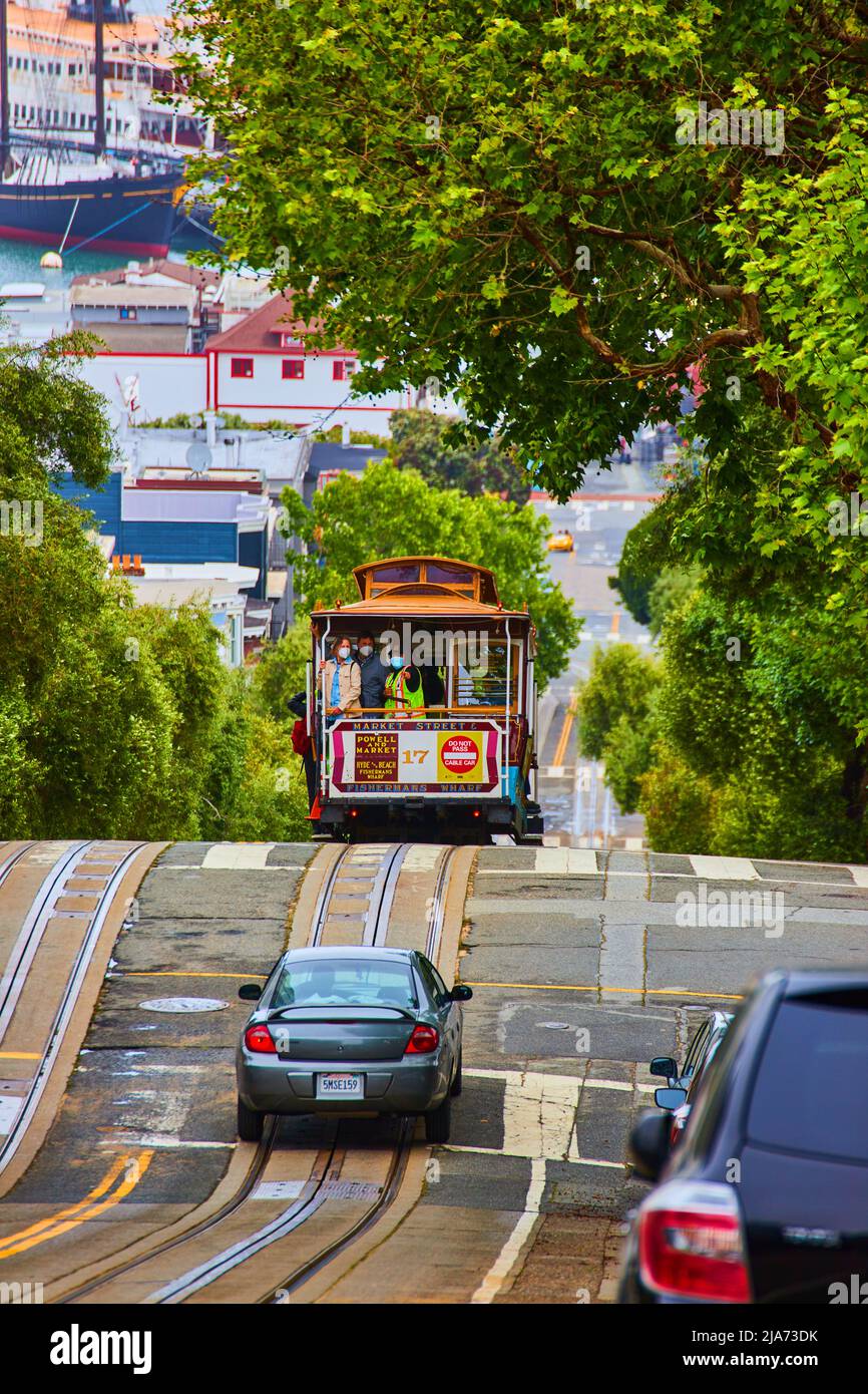 Car and trolley going down steep road in San Francisco, California ...