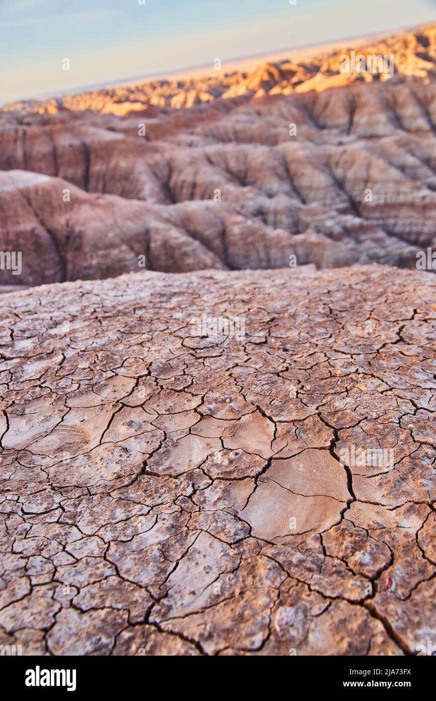 Cracked desert ground with Badlands sediment layers in background Stock ...