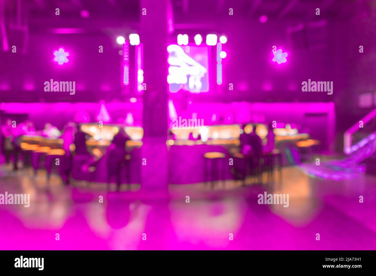 Blurred modern abstract interior of a nightclub with neon purple ...