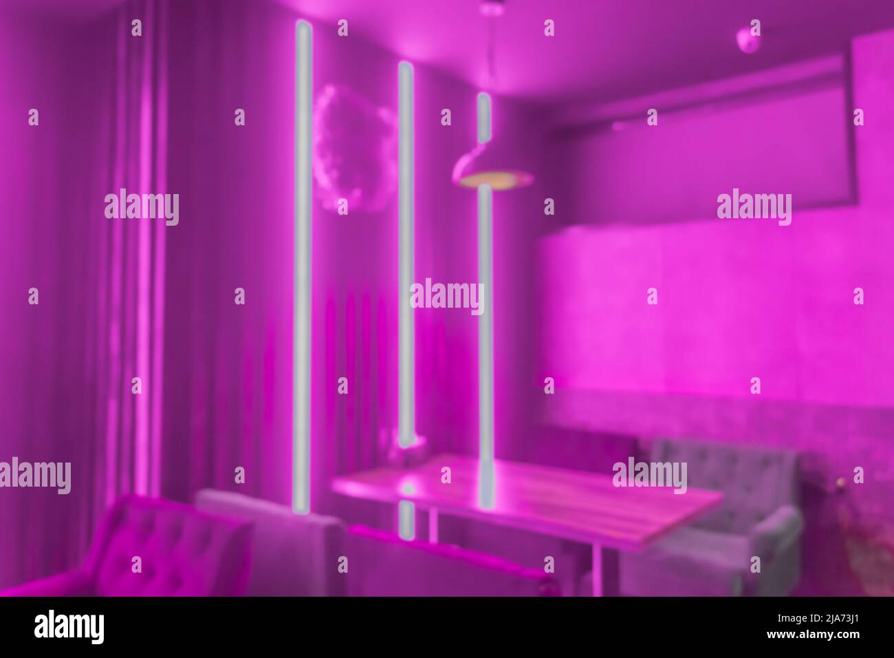 Blurred modern abstract interior of a nightclub with neon purple ...